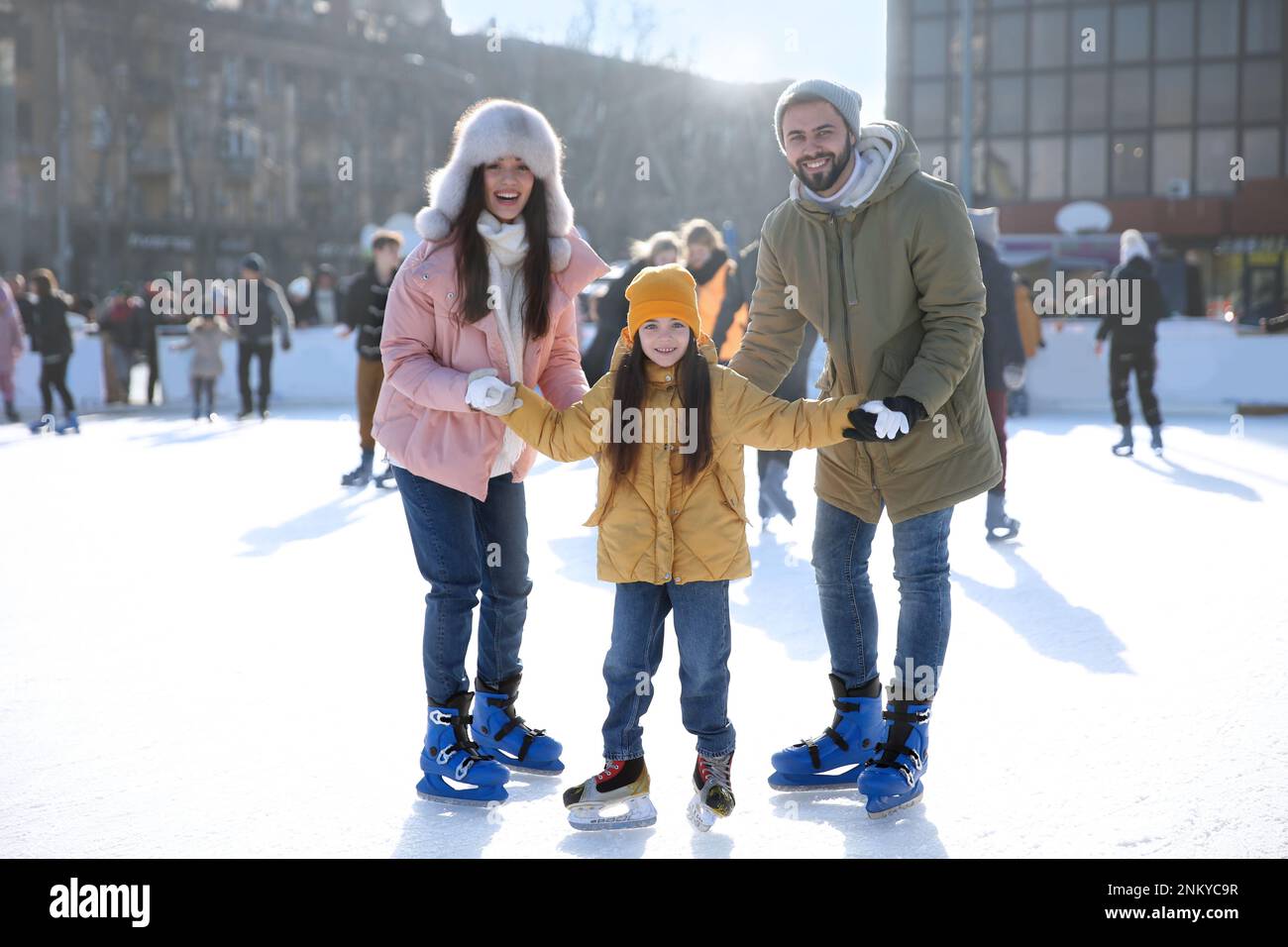 Happy family spending time together at outdoor ice skating rink Stock ...