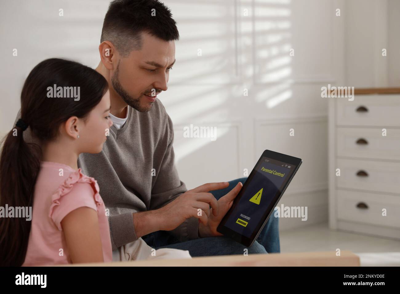 Dad installing parental control on tablet at home. Child safety Stock ...