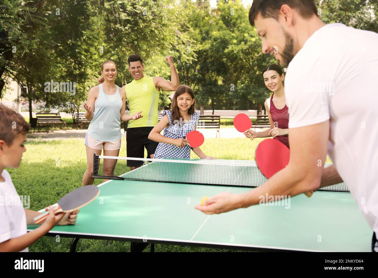 Happy family playing ping pong in park Stock Photo - Alamy