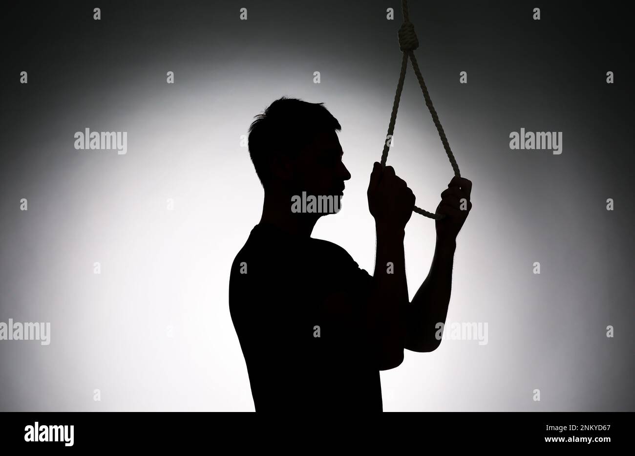 Silhouette of man with rope noose on light background Stock Photo - Alamy