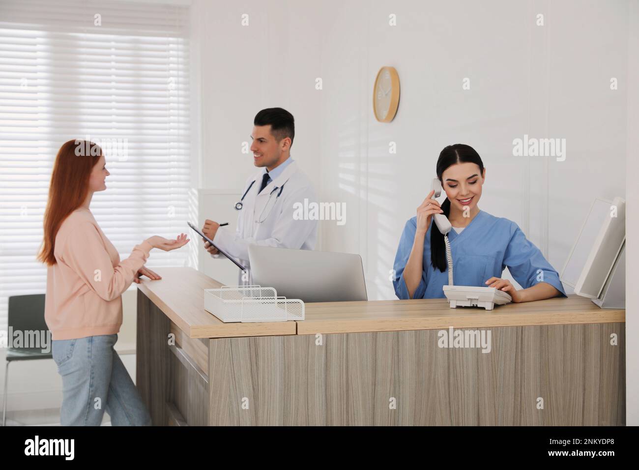Receptionist smiling speaking client hi-res stock photography and ...
