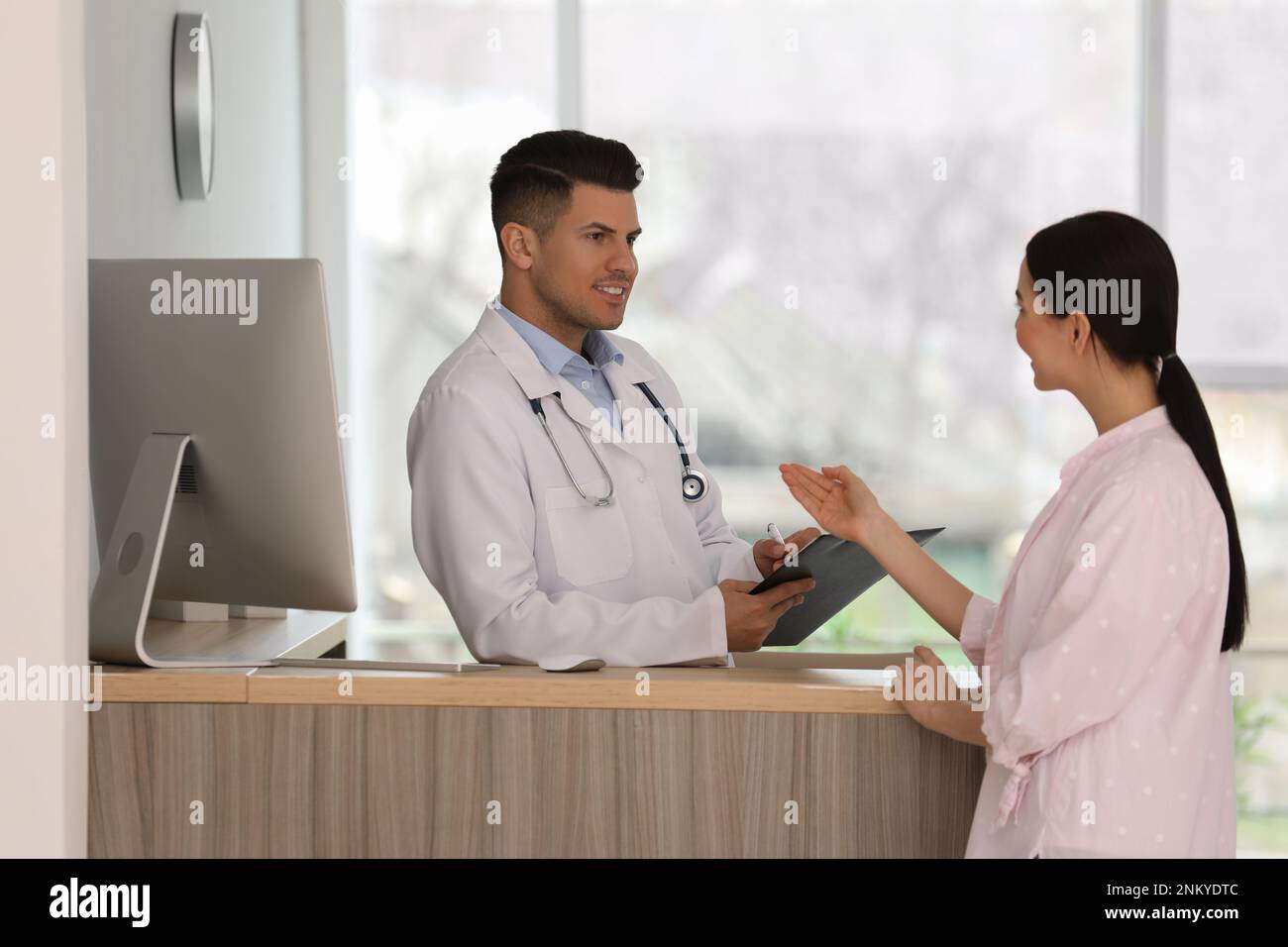 Doctor working with patient at reception in hospital Stock Photo - Alamy