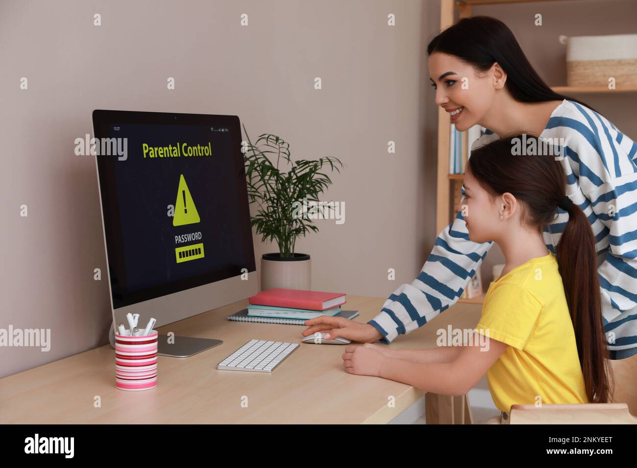 Mom installing parental control on computer at table indoors. Child ...