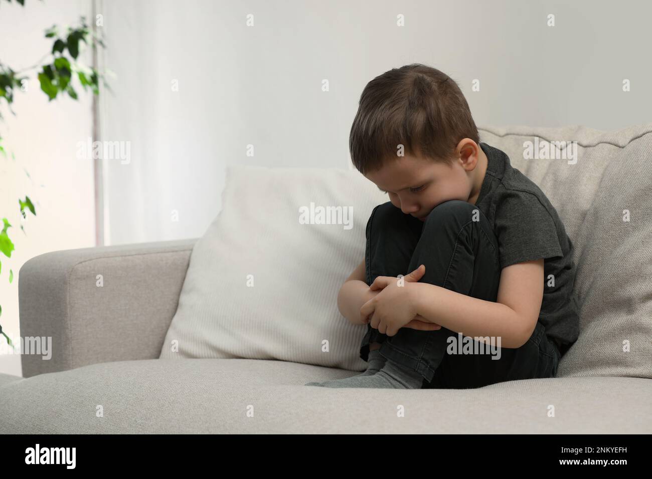 Sad little boy on sofa at home Stock Photo - Alamy