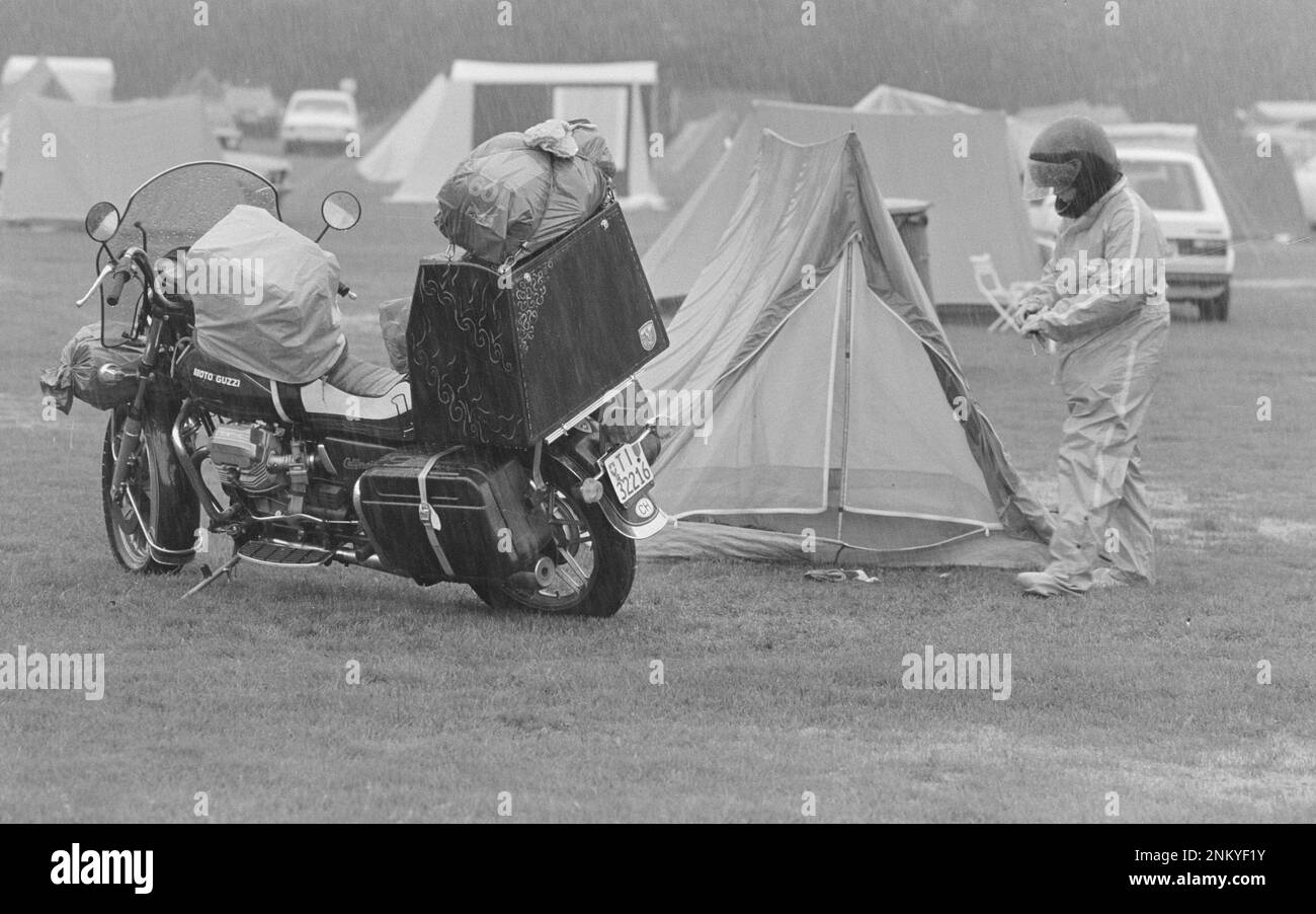 Very bad summer weather; motorcyclist leaving from campsite in the rain ...