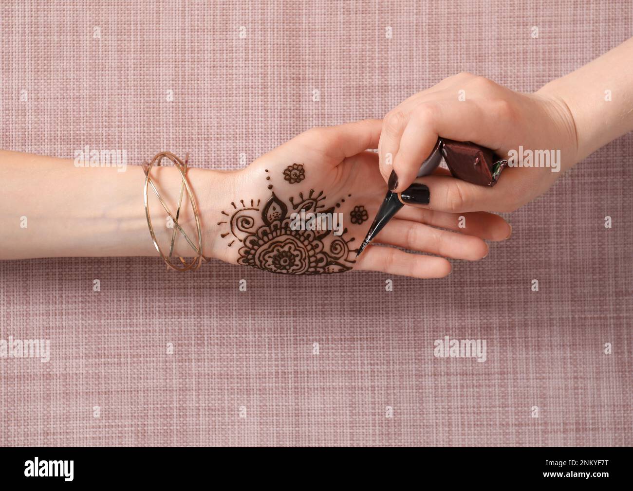 Professional mehndi master making henna tattoo at table, top view Stock ...