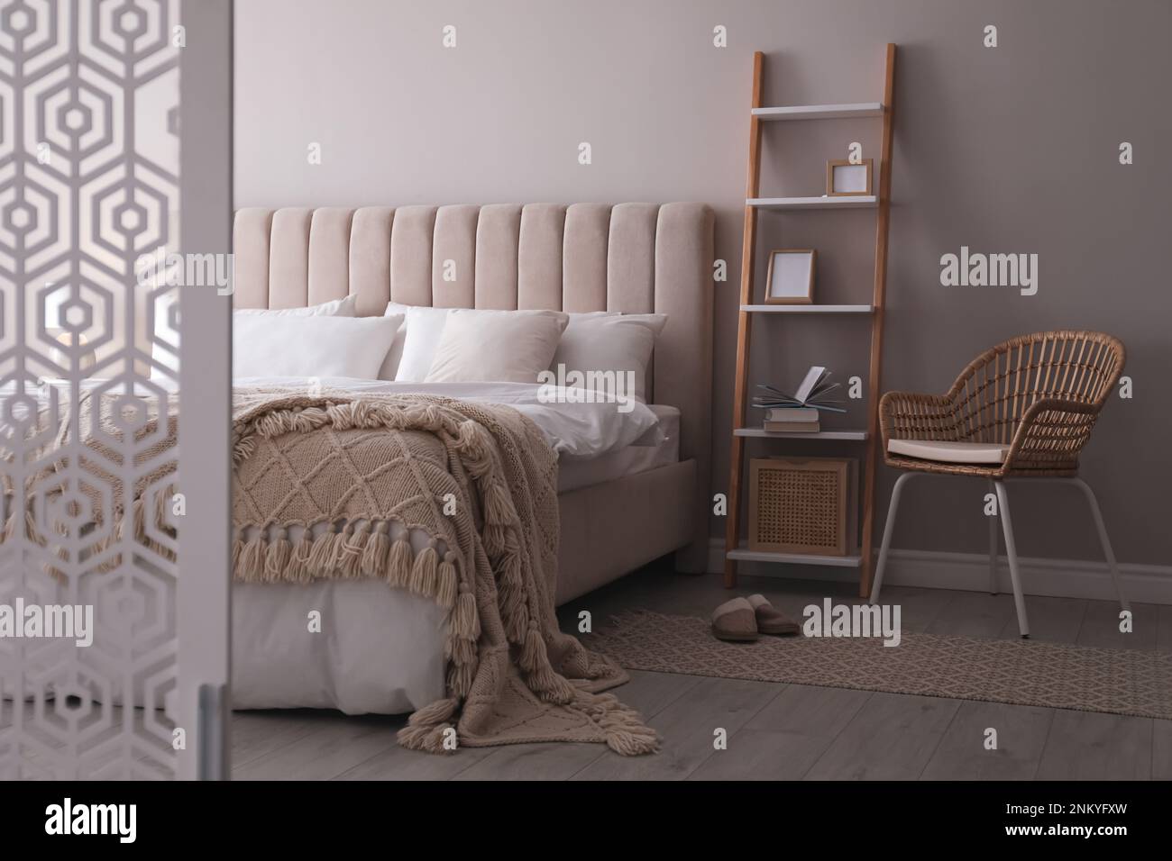 Cozy bed with soft linens in light room Stock Photo - Alamy