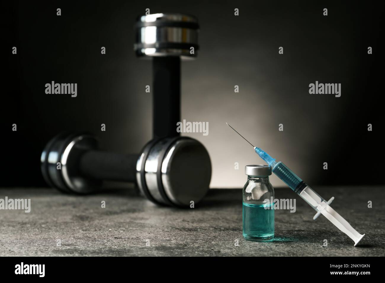 Vial, syringe with drug near sports equipment on grey table, space for ...