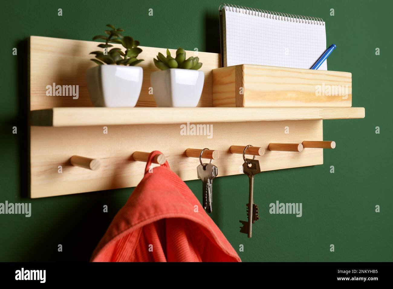 Wooden hanger for keys with clothes on green wall, closeup Stock Photo ...