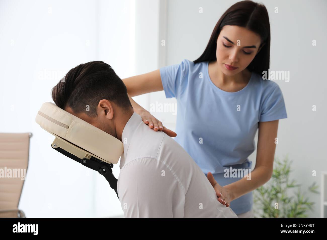 Man receiving massage in modern chair indoors Stock Photo - Alamy