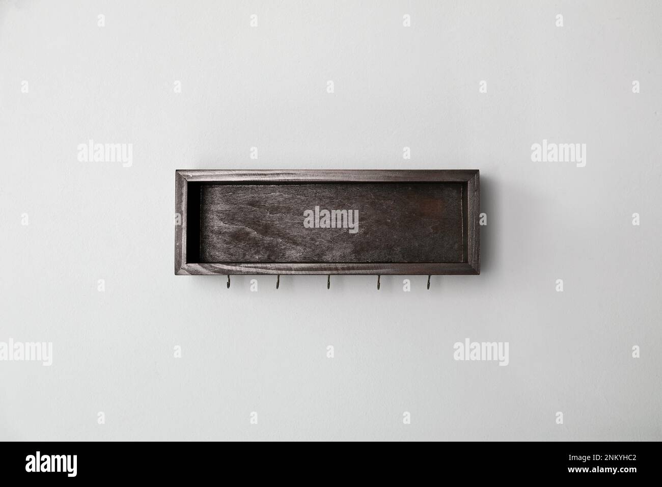 Wooden hanger for keys on light grey wall Stock Photo - Alamy