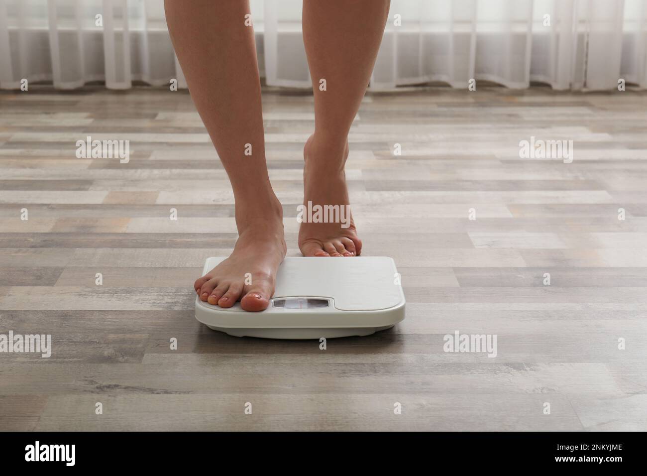 Woman stepping on floor scales indoors, closeup. Weight control Stock ...