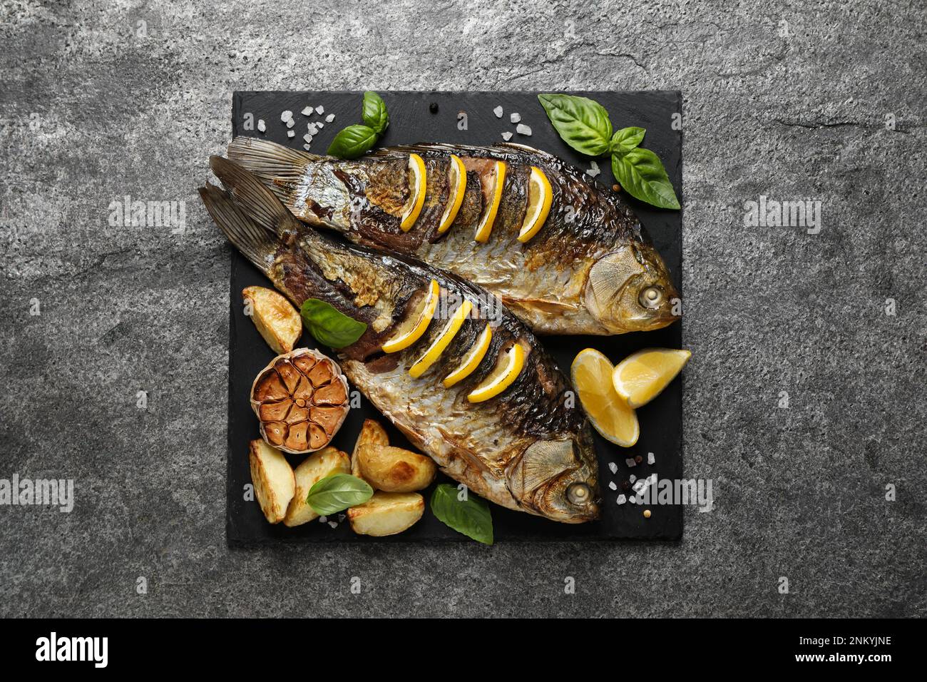 Tasty homemade roasted crucian carps served on grey table, top view ...