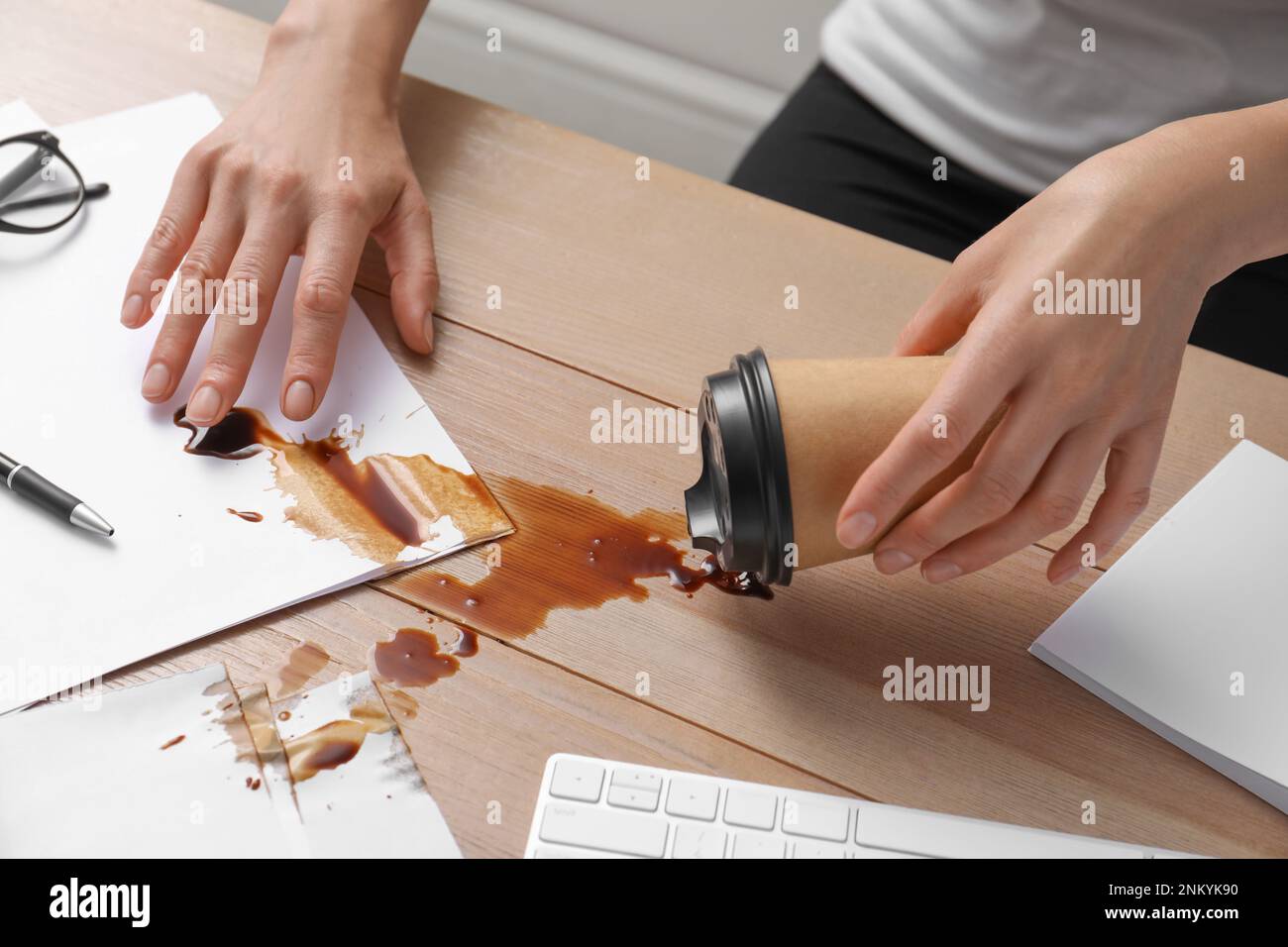 Woman spilled coffee on wooden office desk, closeup Stock Photo - Alamy