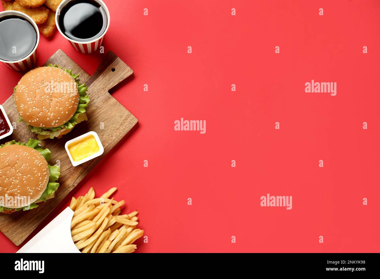 Flat lay composition with delicious fast food menu on red background ...