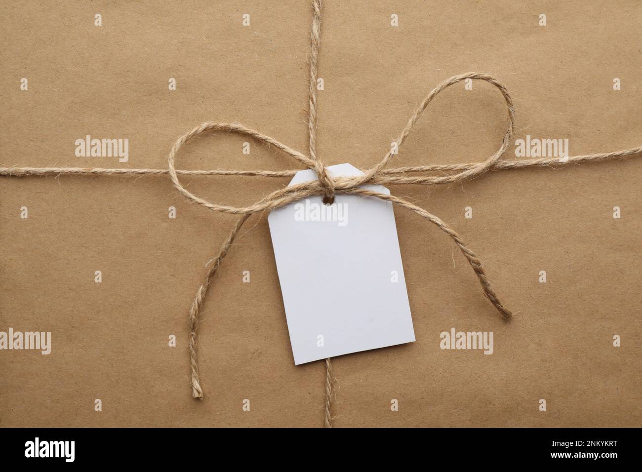 Parcel wrapped in kraft paper with tag as background, closeup Stock ...