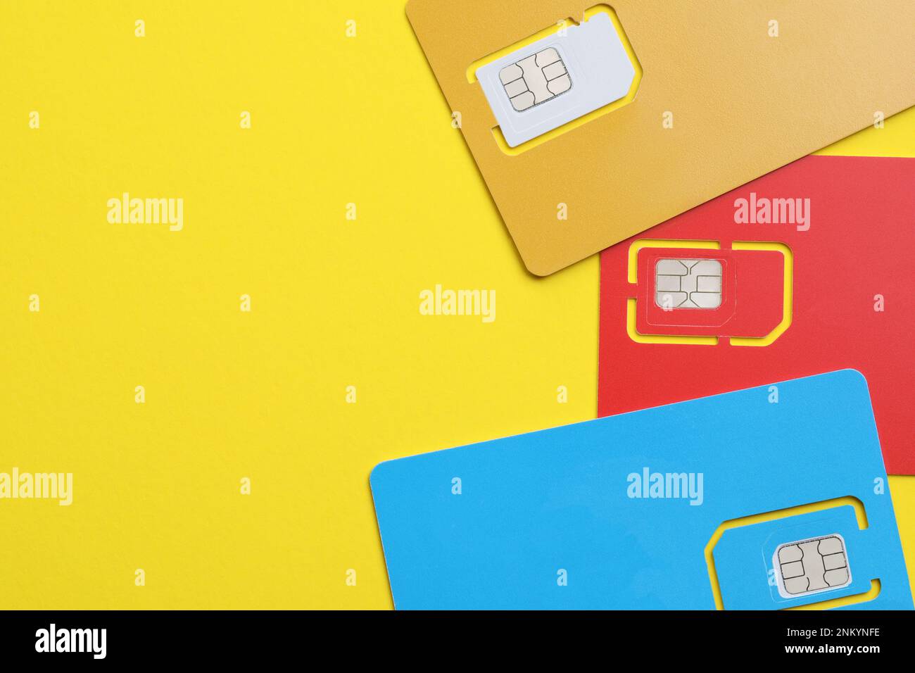 Different SIM cards on yellow background, flat lay. Space for text ...