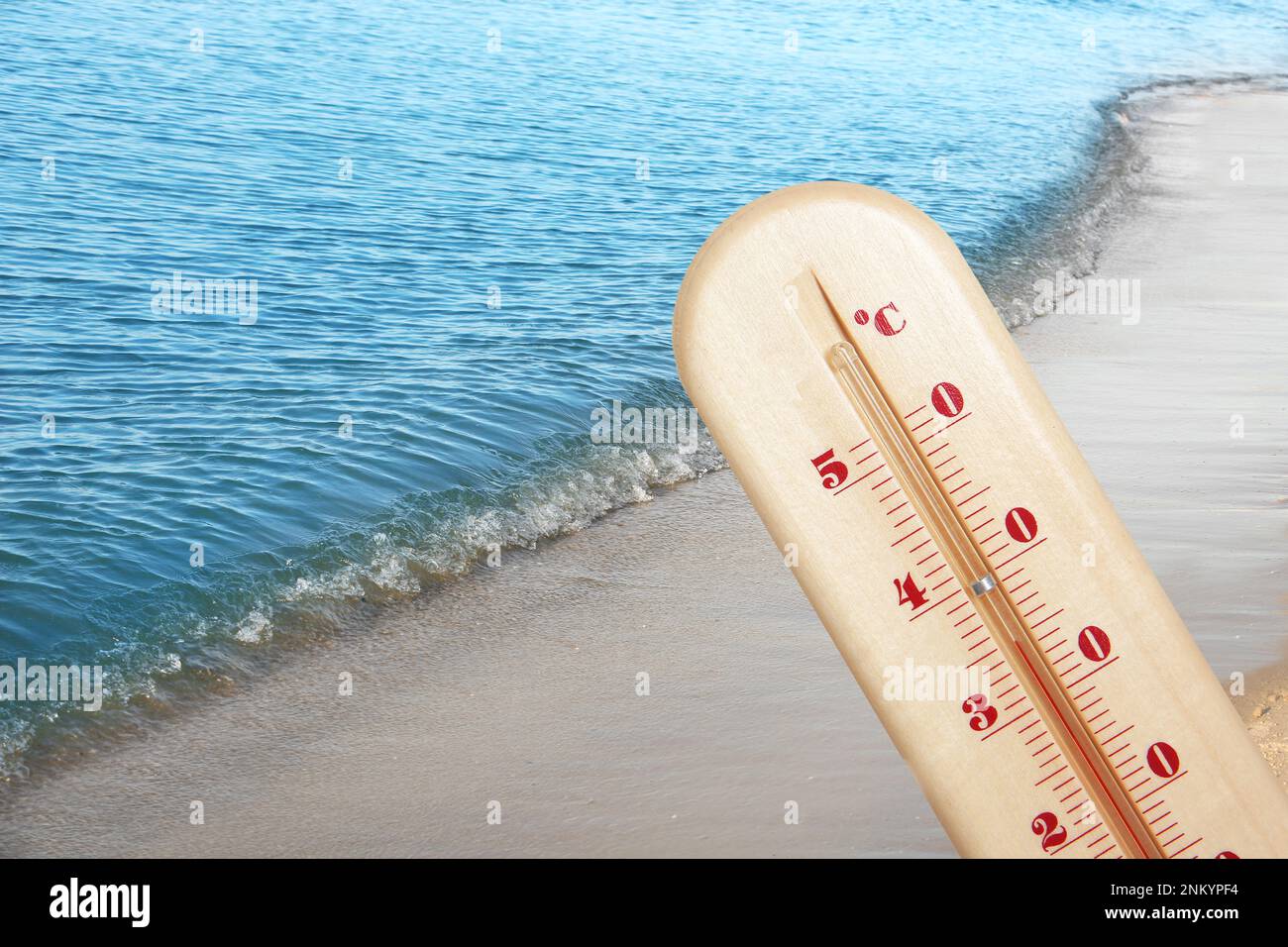 Closeup view of weather thermometer and beautiful seashore on ...