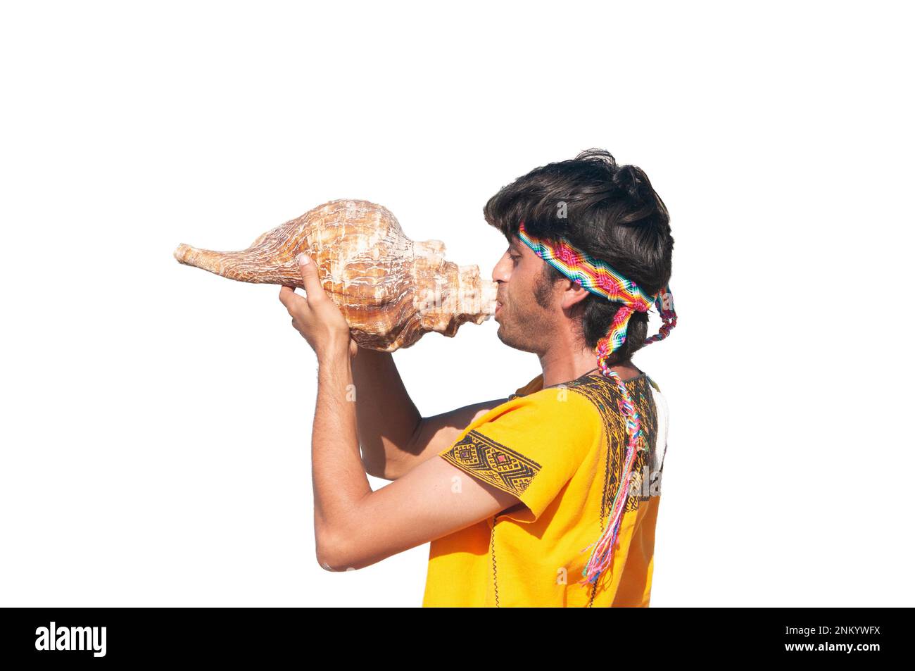 Mexican man in traditional costume in profile plays sea shell with ...