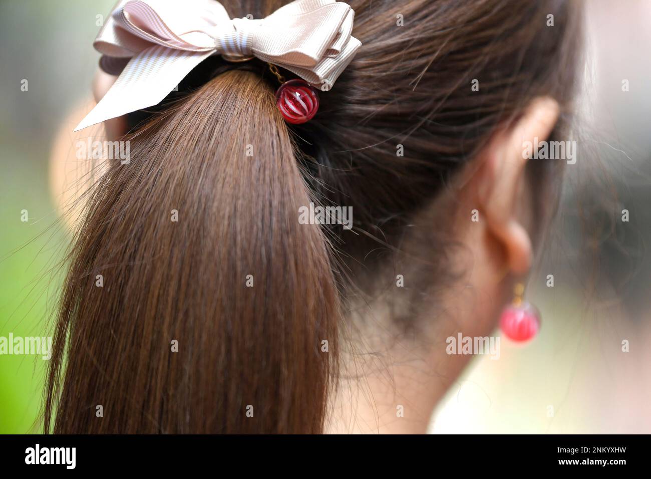 A woman weats an ear ring made of resin coated candy at nanaco plus+ ...