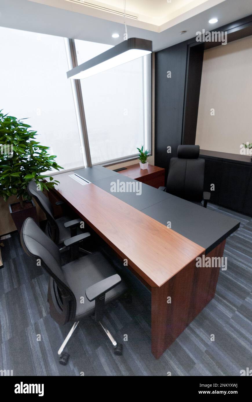 A professional office setting featuring a large wooden desk and four ...