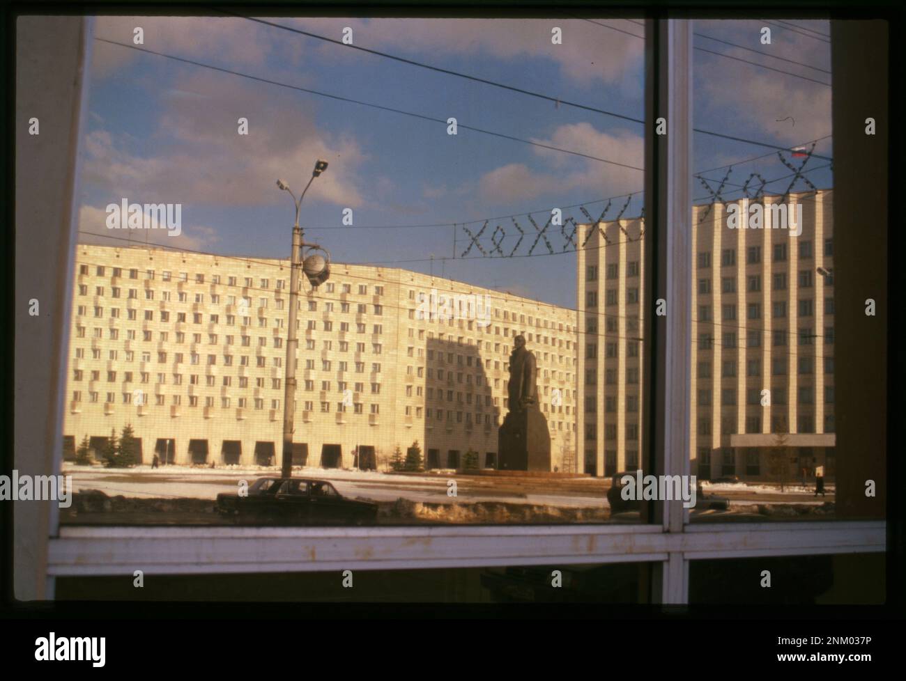 A reflective window view of Lenin Square in Arkhangel'sk captures both ...