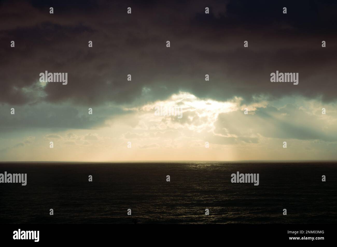 The sun's rays fall on the surface of the sea through the clouds. Not dense rain clouds Stock ...