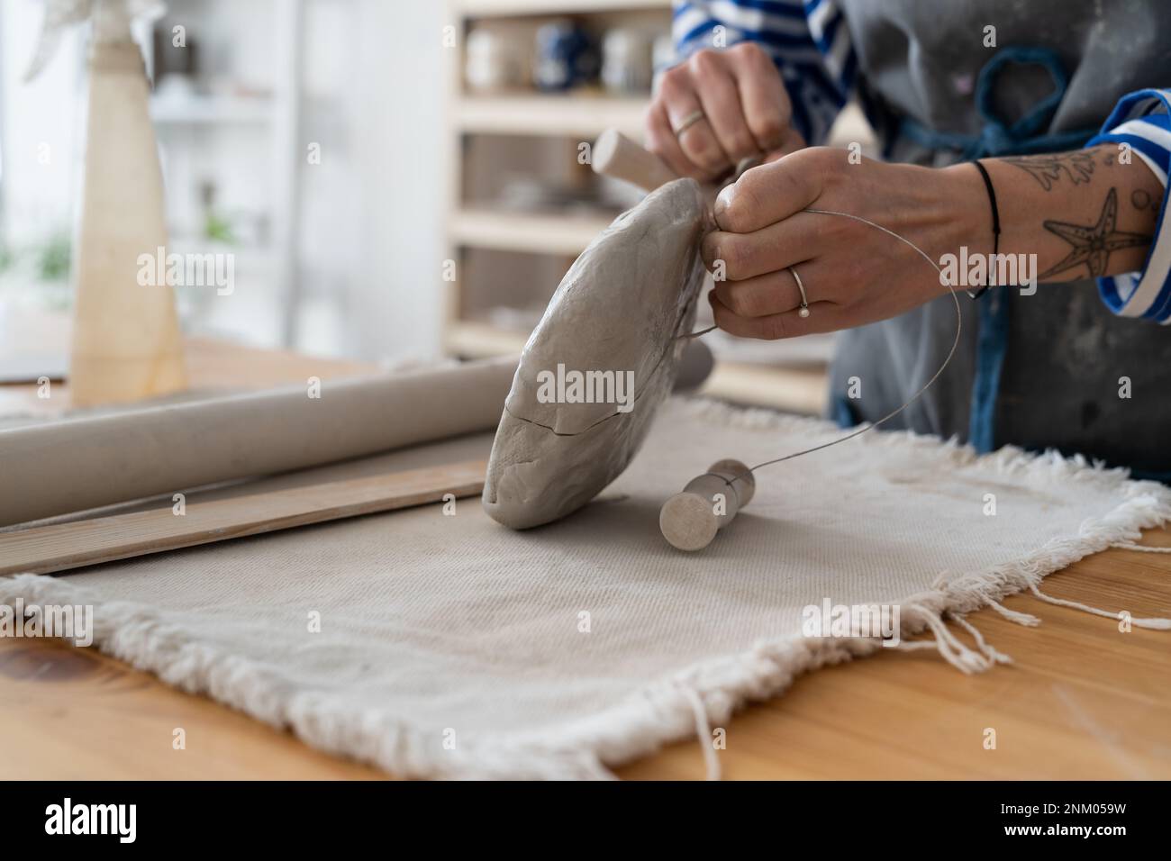 Potter sculptor cutting clay with the string in workshop for sale in ...