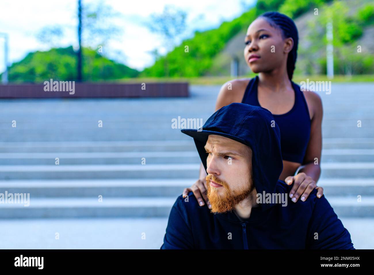 two sad person sitting outdoors on stairs sity background Stock Photo ...