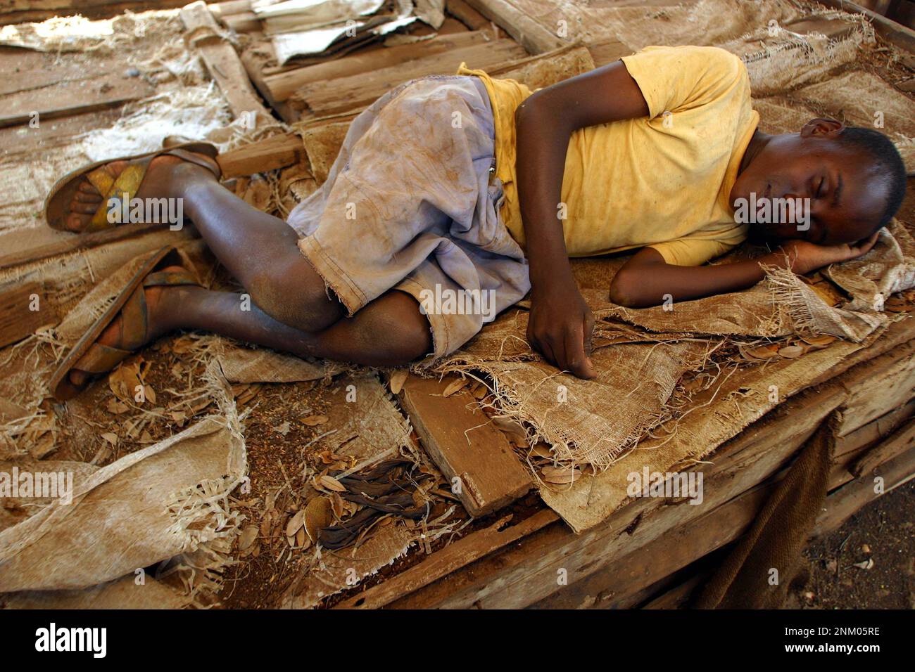 STREET CHILD SLEEPING ROUGH UNDERNEATH A MARKET SCHOOL. TANZANIA ...