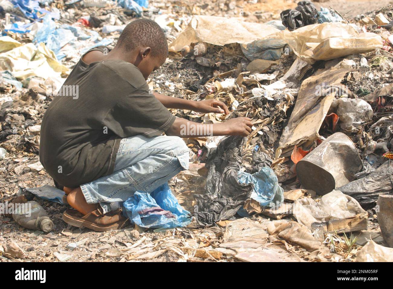 A STREET CHILD PICKING THROUGH THE RUBBISH DUMPS. IN TANZANIA. PICTURE ...