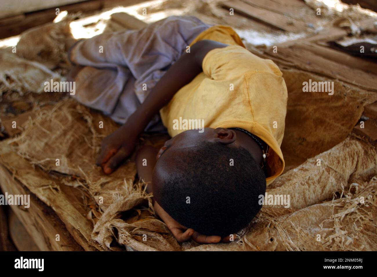 STREET CHILD SLEEPING ROUGH UNDERNEATH A MARKET SCHOOL. TANZANIA ...