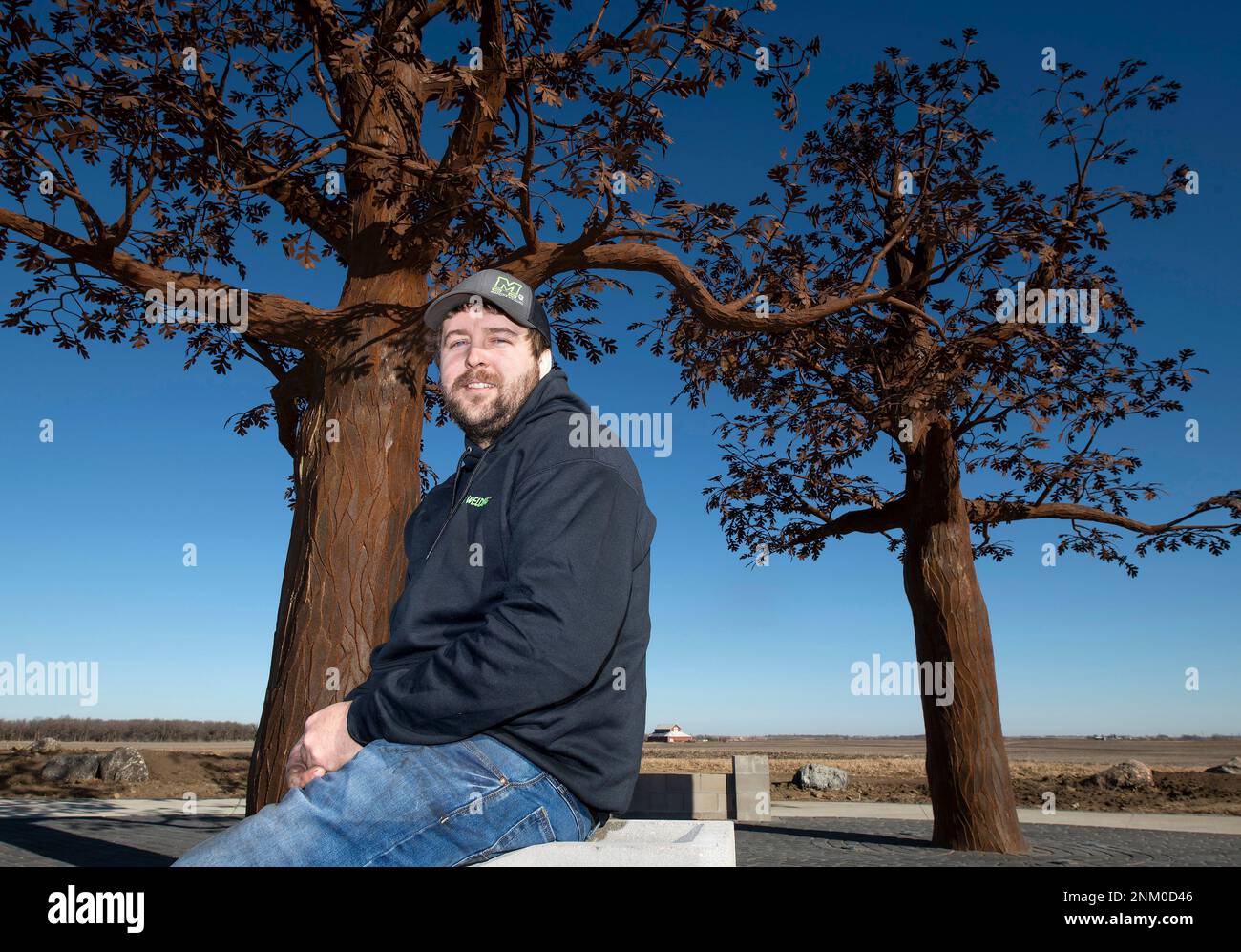 Welder Tanner King sits underneath a pair of metal oak trees Wednesday ...