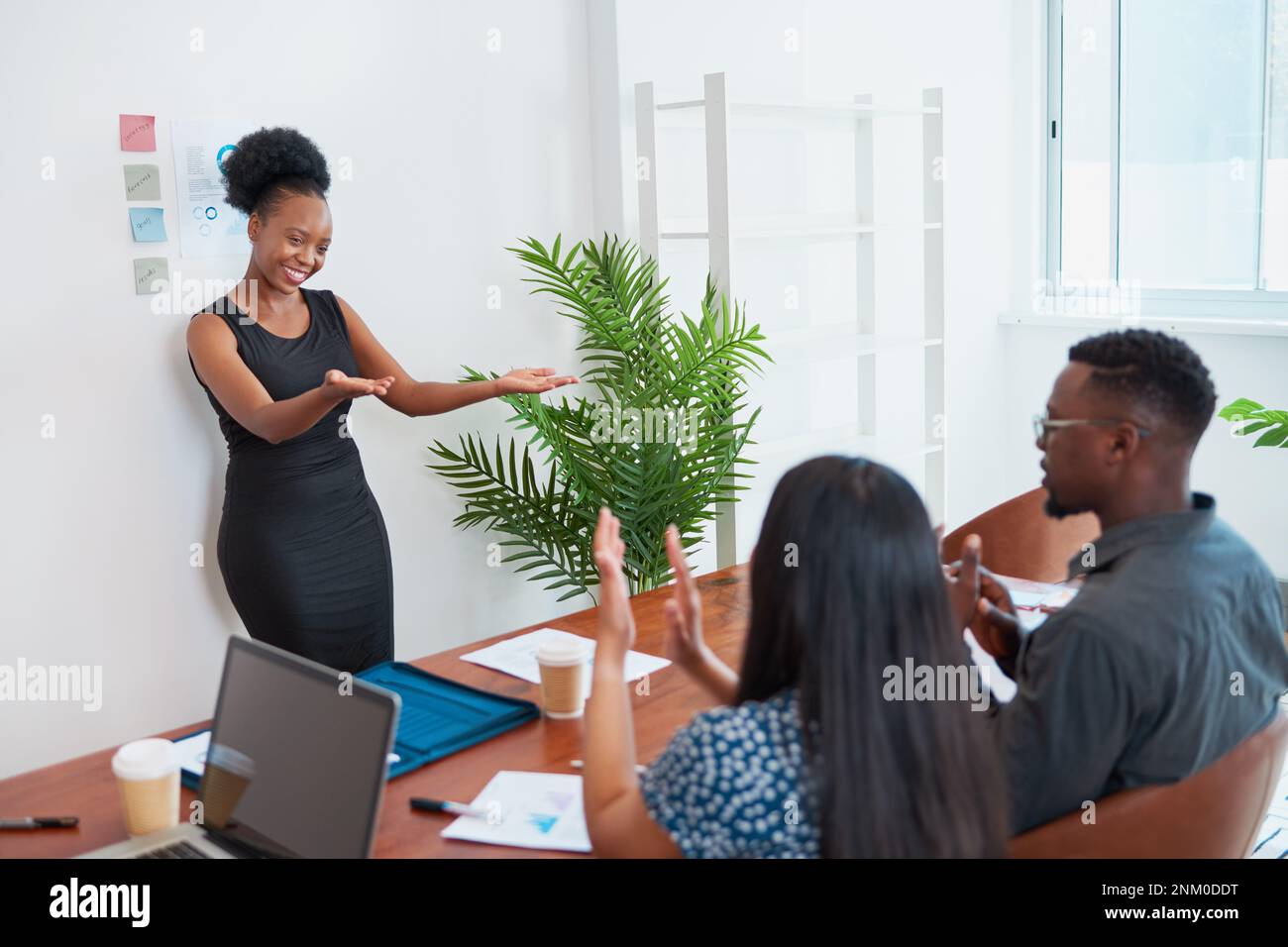 Black business woman thanks attendees at the end of presentation ...