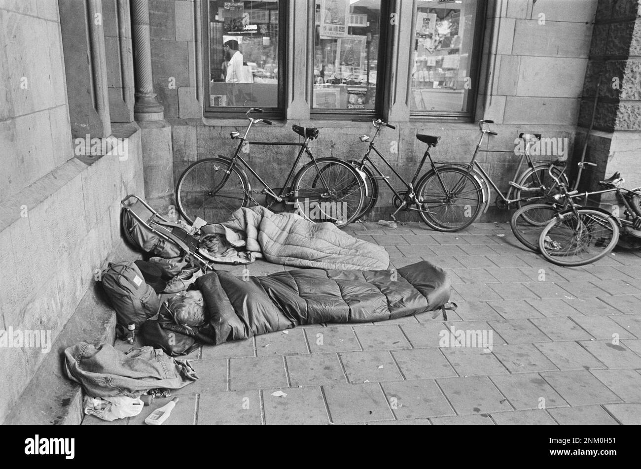 Homeless men sleeping outdoors in Amsterdam, possibly at the Central ...