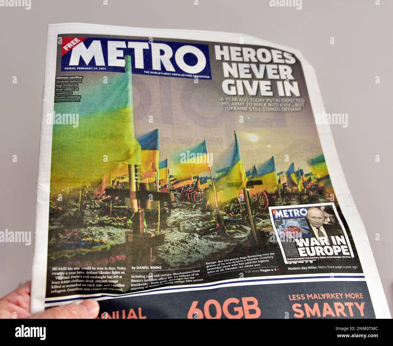 A man's hand holds a copy of the Metro newspaper published on 24th ...