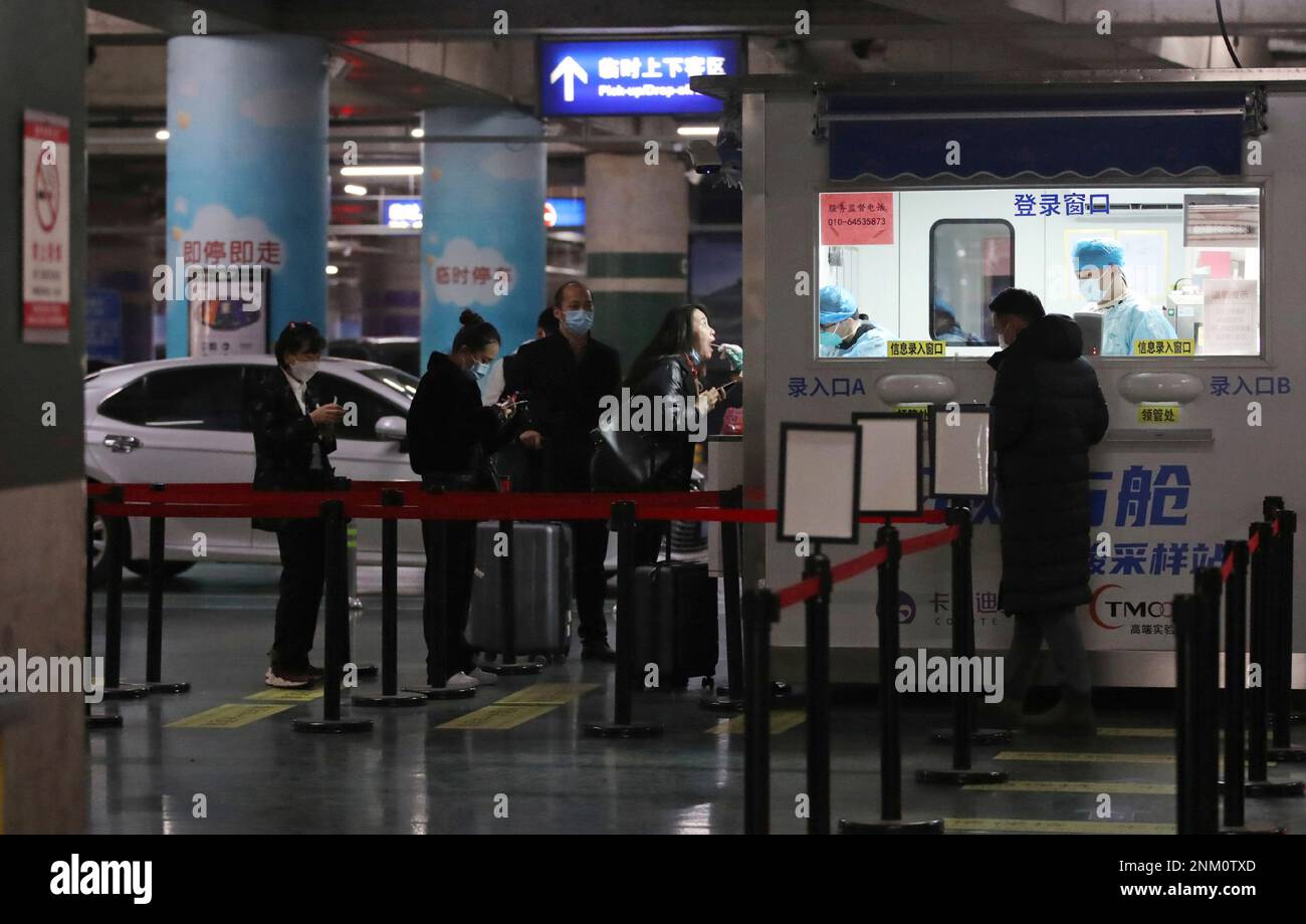 Workers receive a PCR test at the basement booth of the Beijing Capital ...