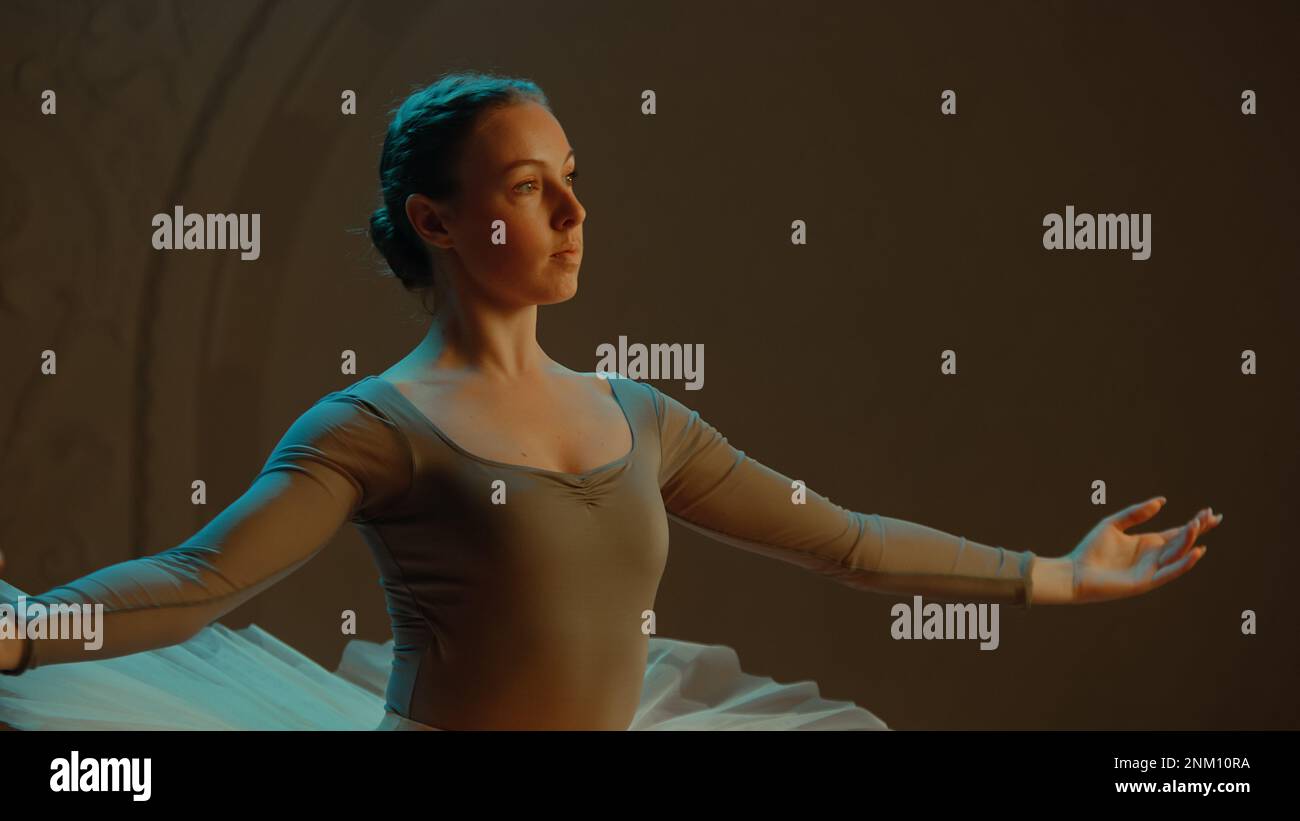 Cinematic shot of beautiful classical ballet female dancer in white ...