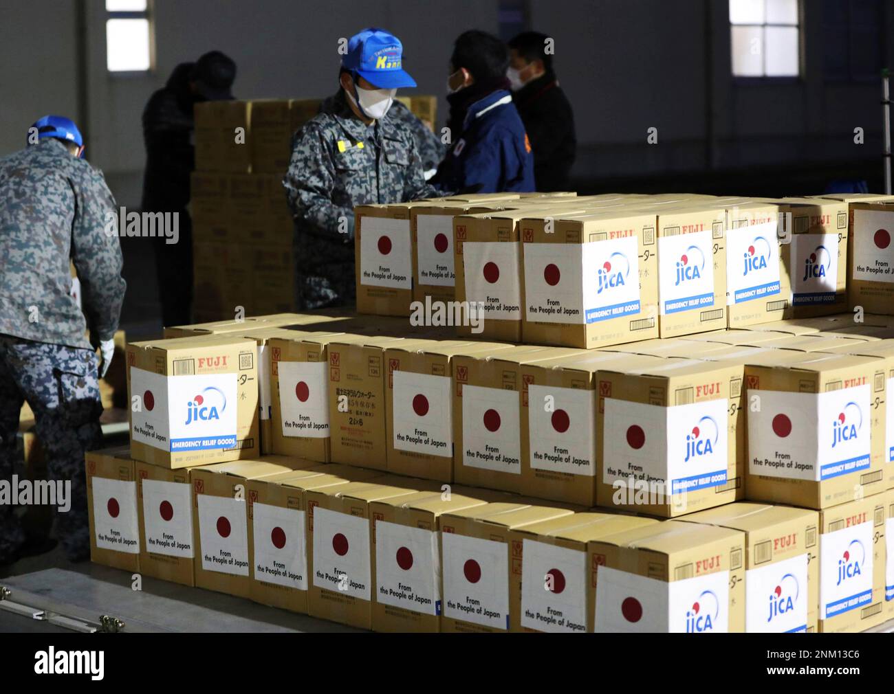 Japan Self-Defense Forces officials load drinking water into transport ...