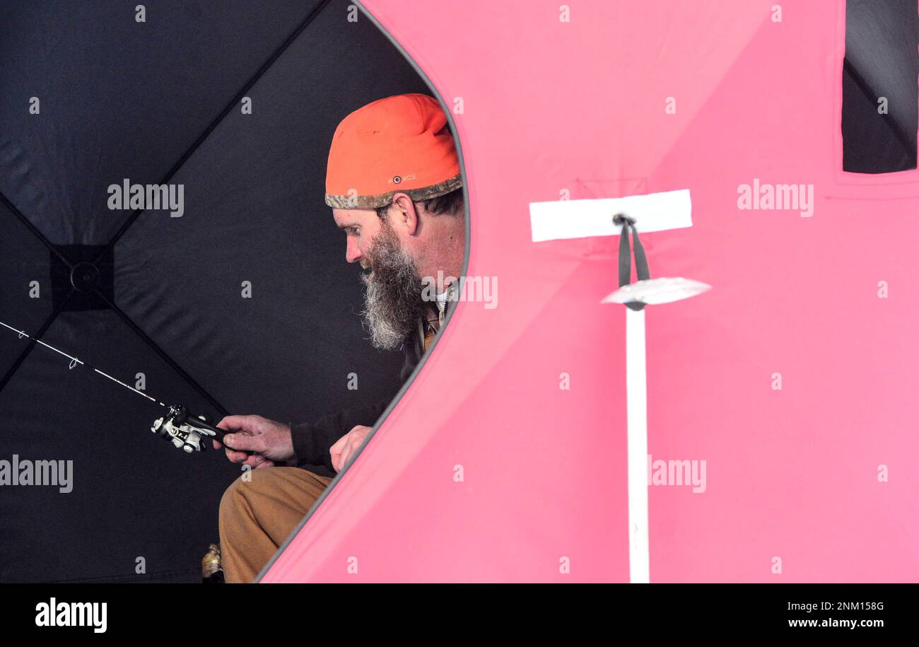 Todd Carpenter, of Dummerston, Vt., sits in his ice shanty while ...