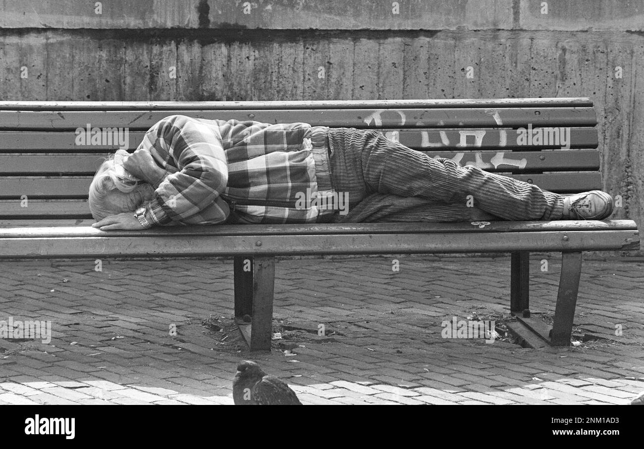 Homeless man sleeping on a bench Black and White Stock Photos & Images ...