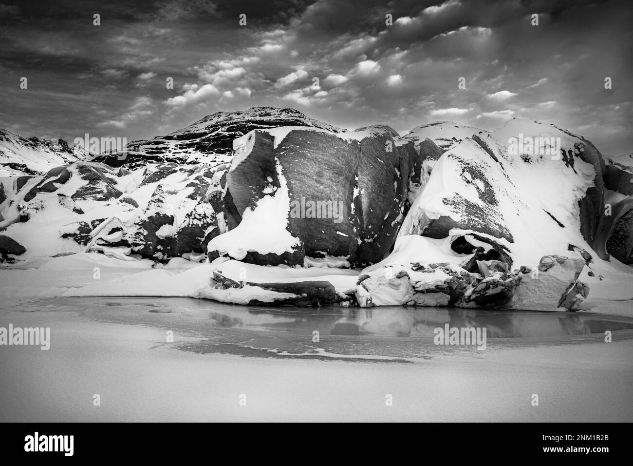 A picturesque winter scene featuring a frozen lake set against a ...