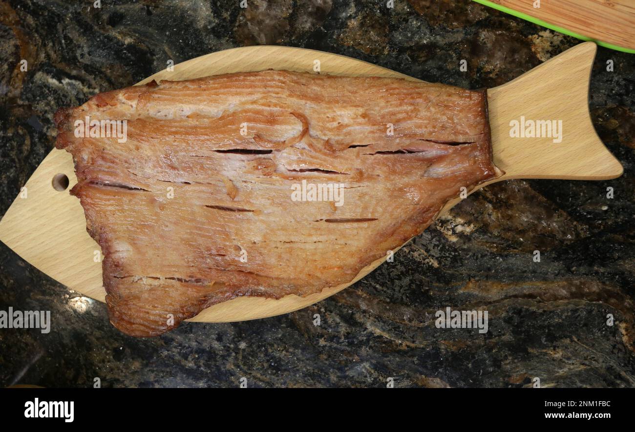 Smoked carp fillet seen on the fish-shaped cutting board Stock Photo ...