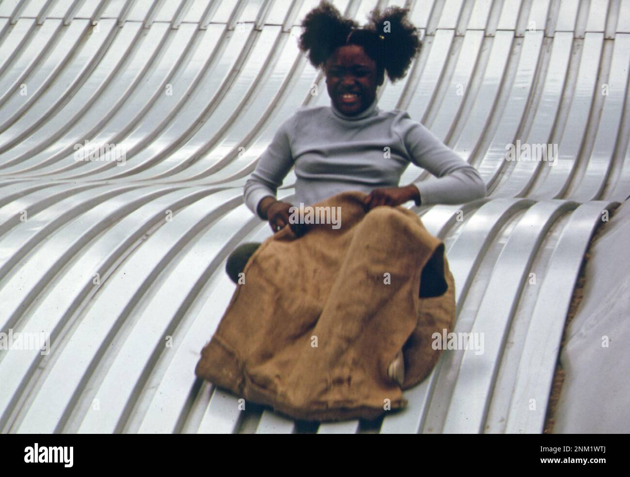 1970s America: African American girl having fun on the Super-slide at ...
