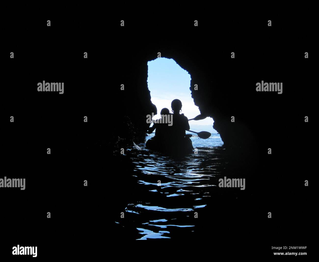 Kayakers paddle through a rock arch and explore sea caves at Channel ...
