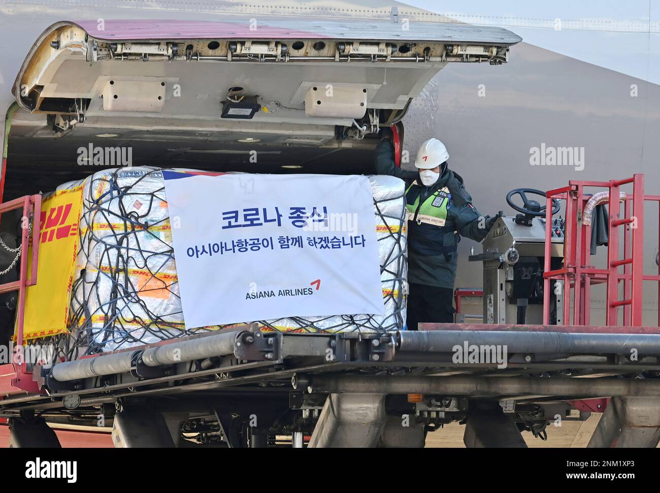 Workers unload a cargo shipment containing the first batches of Pfizer ...