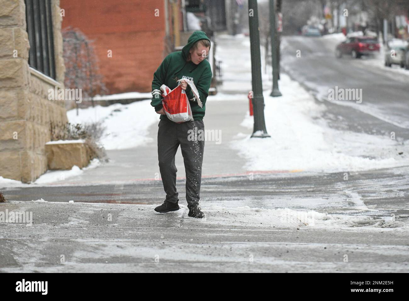 Amy Rountree puts down rock salt on the pavement in front of Pressed ...