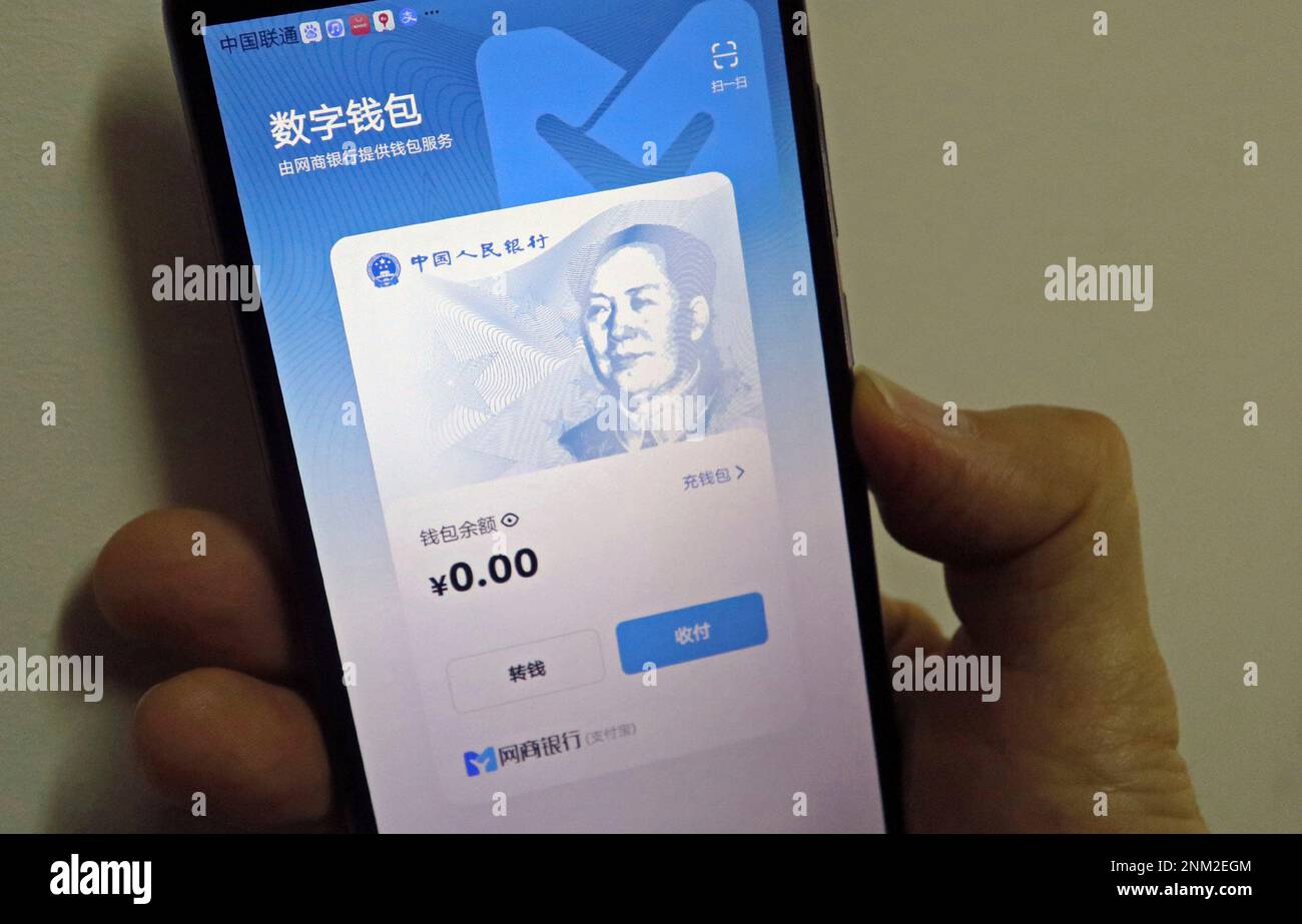 A smartphone monitor shows an application for Chinese yuan, known as ...