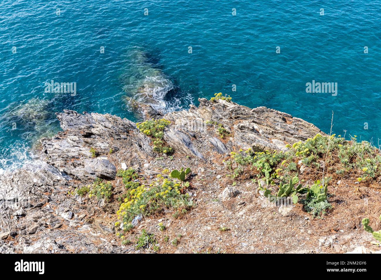 View down a cliff to the ocean below in daylight Stock Photo - Alamy