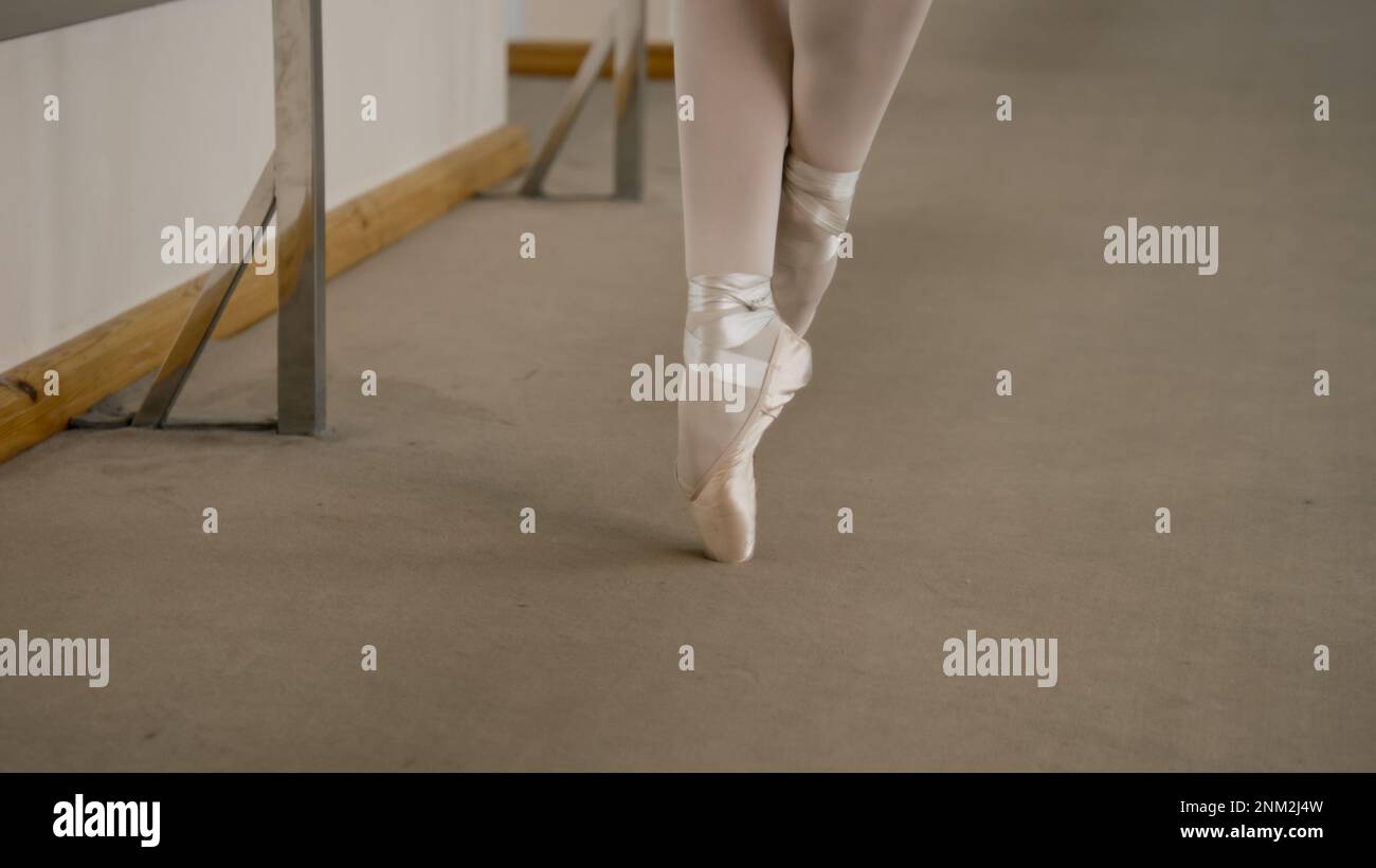 Close-up feet shooting of professional ballerina standing on tiptoe in ...